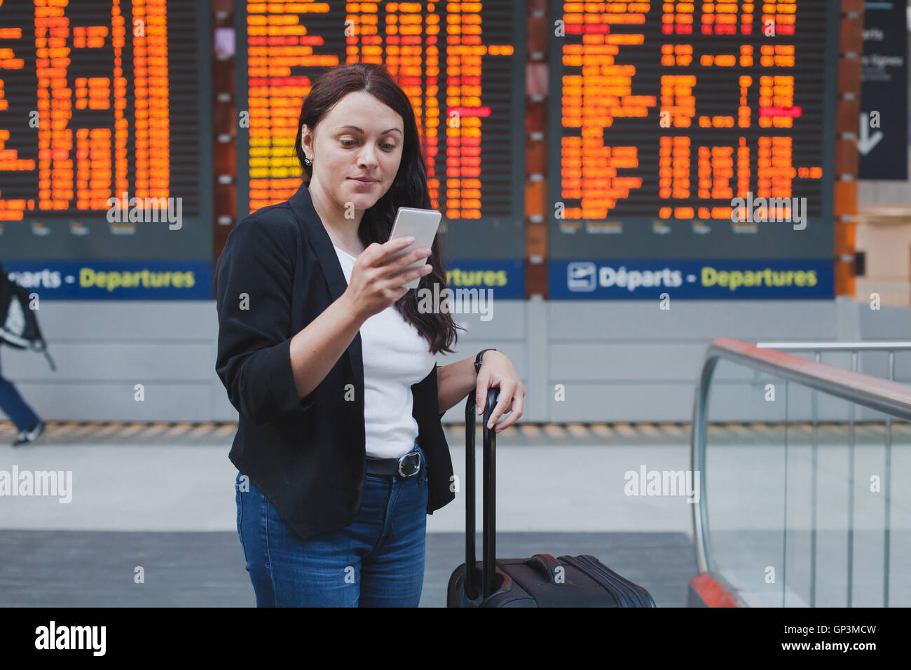 woman with smartphone in international airport checking timetable of ...