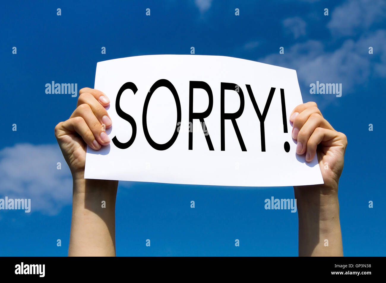 sorry, concept, hands holding sign in blue sky Stock Photo - Alamy