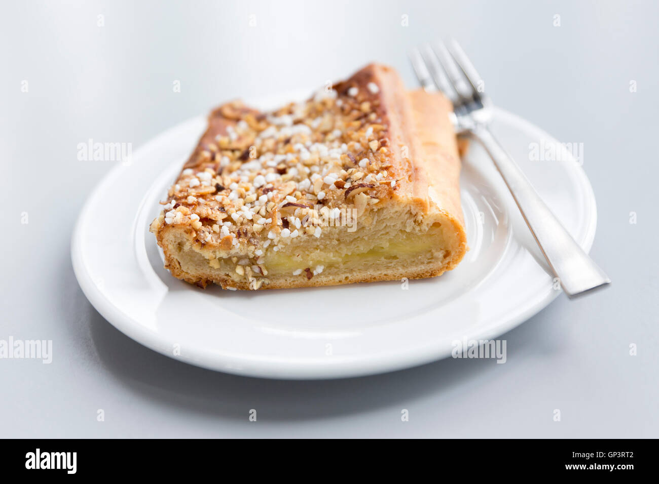 Danish pastry on white plate with fork - traditional sweet cake with ...