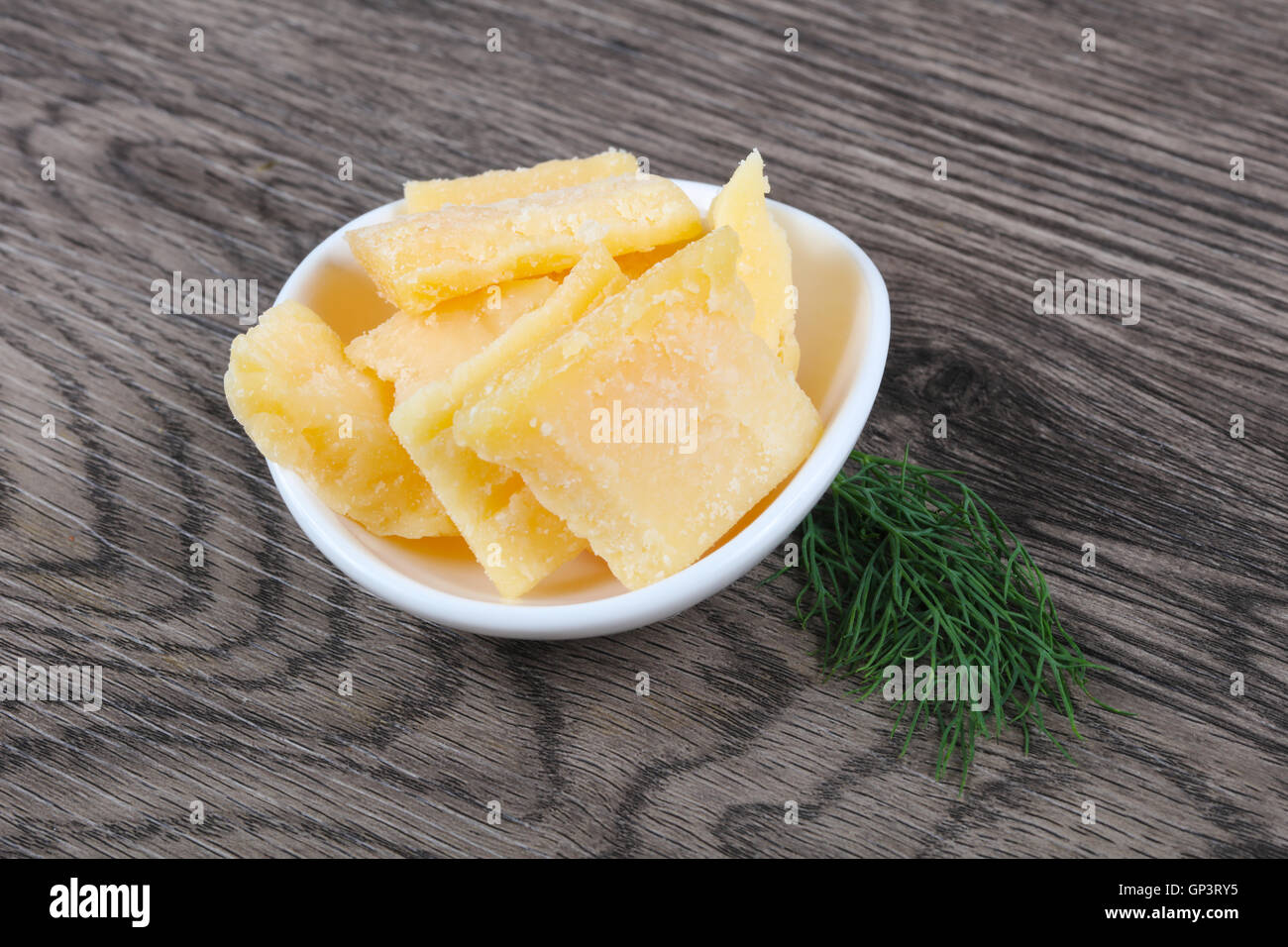 Crunchy parmesan cheese in the bowl on wood background Stock Photo - Alamy