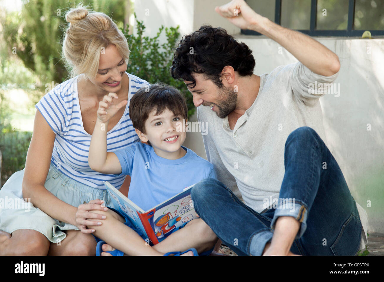 Parents teaching child to read Stock Photo - Alamy
