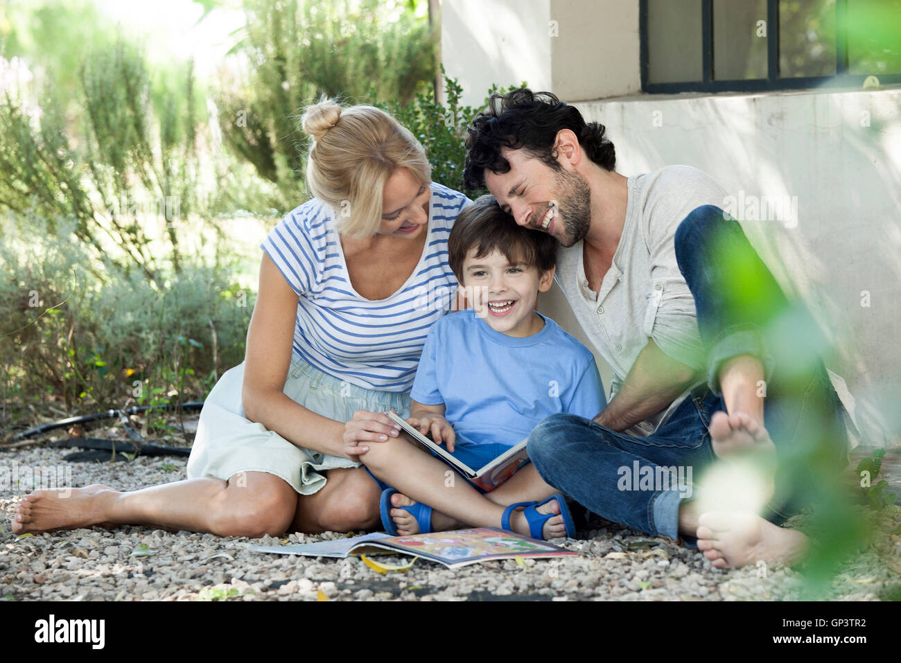 Parents reading book with child Stock Photo - Alamy