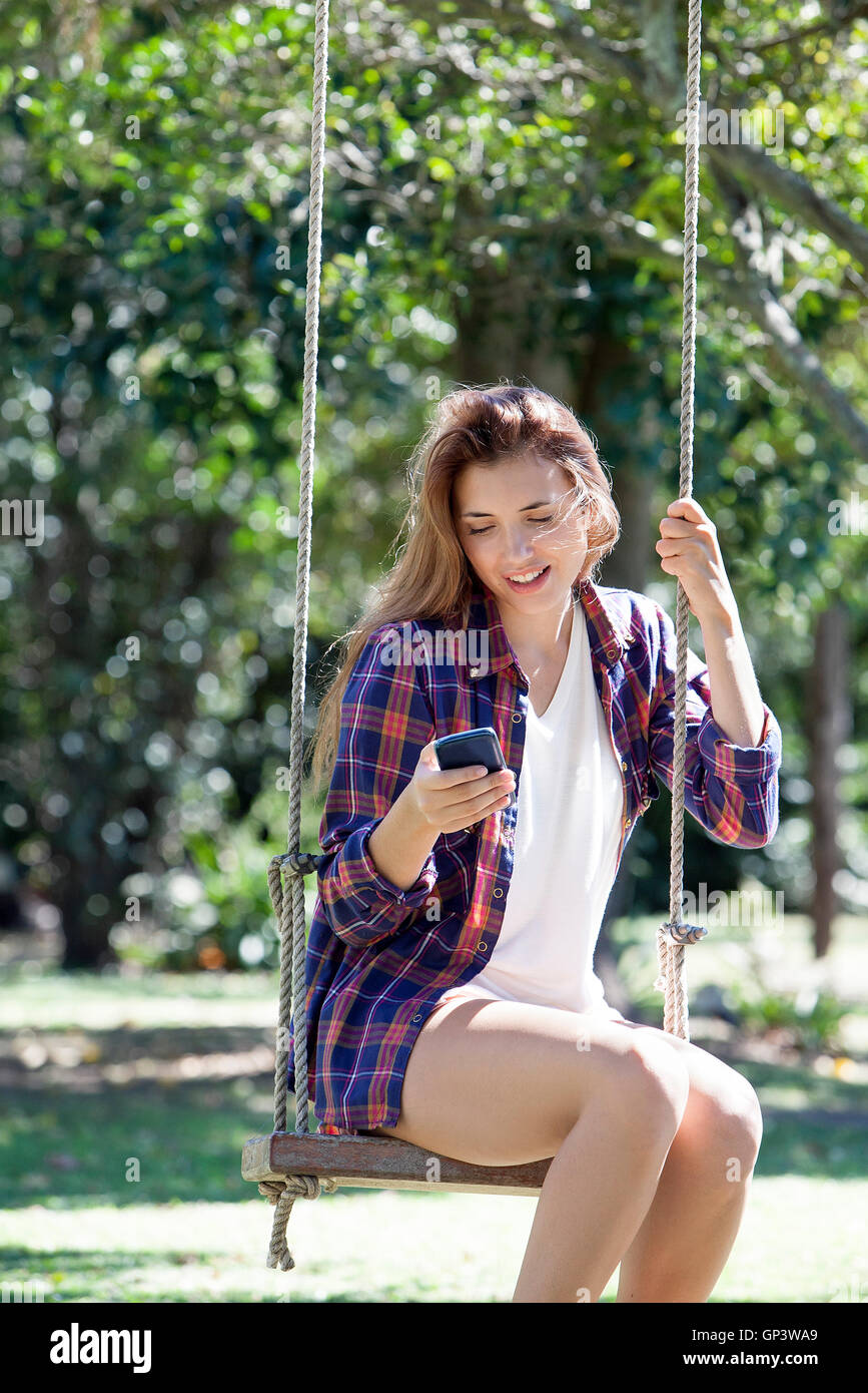 Woman on swings smartphone hi-res stock photography and images - Alamy