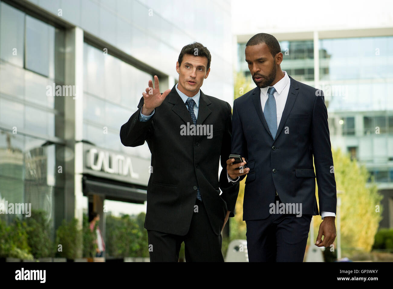 Businessmen walking and talking together outdoors Stock Photo - Alamy