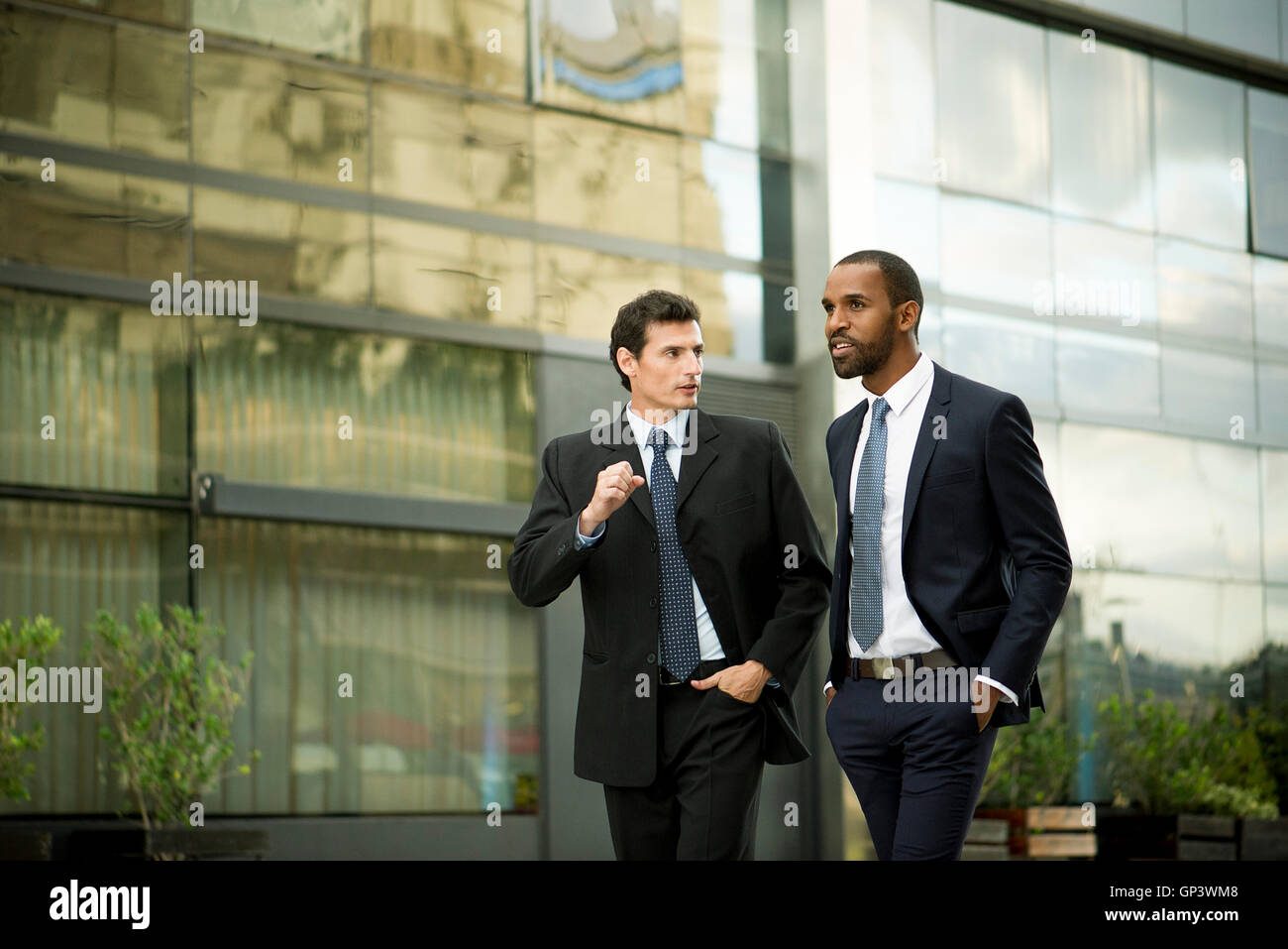 Businessmen walking and talking together Stock Photo - Alamy