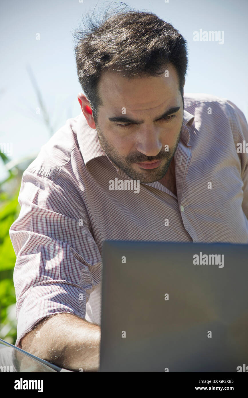Man using laptop computer outdoors Stock Photo - Alamy