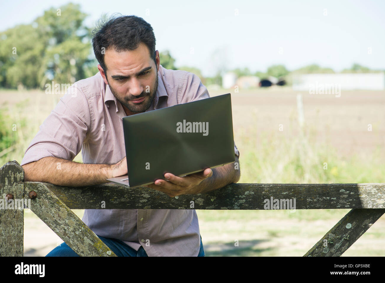 Farmer using laptop while out in field Stock Photo - Alamy