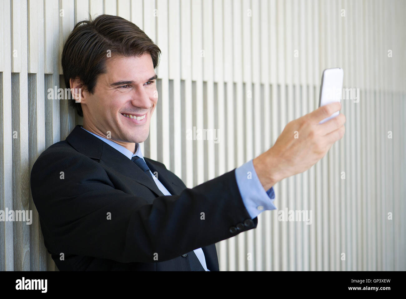 Businessman using smartphone to take a selfie Stock Photo - Alamy