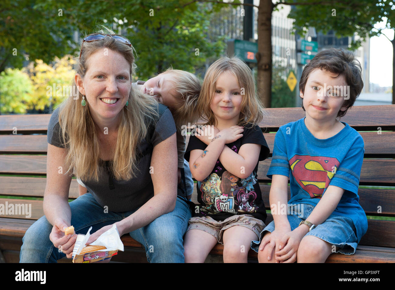 Family sitting together on bench, portrait Stock Photo - Alamy