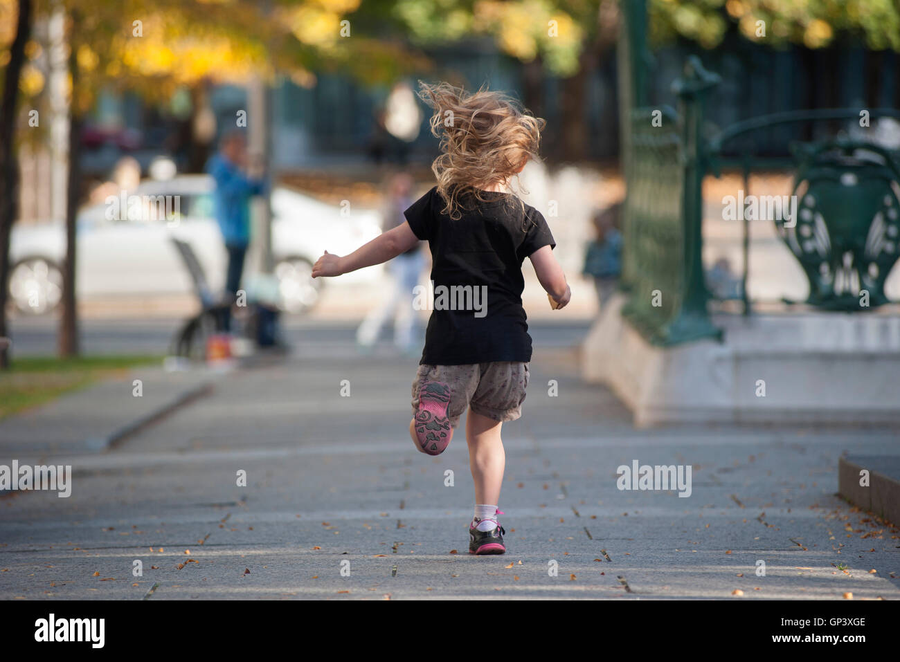 Little girl running on sidewalk Stock Photo - Alamy
