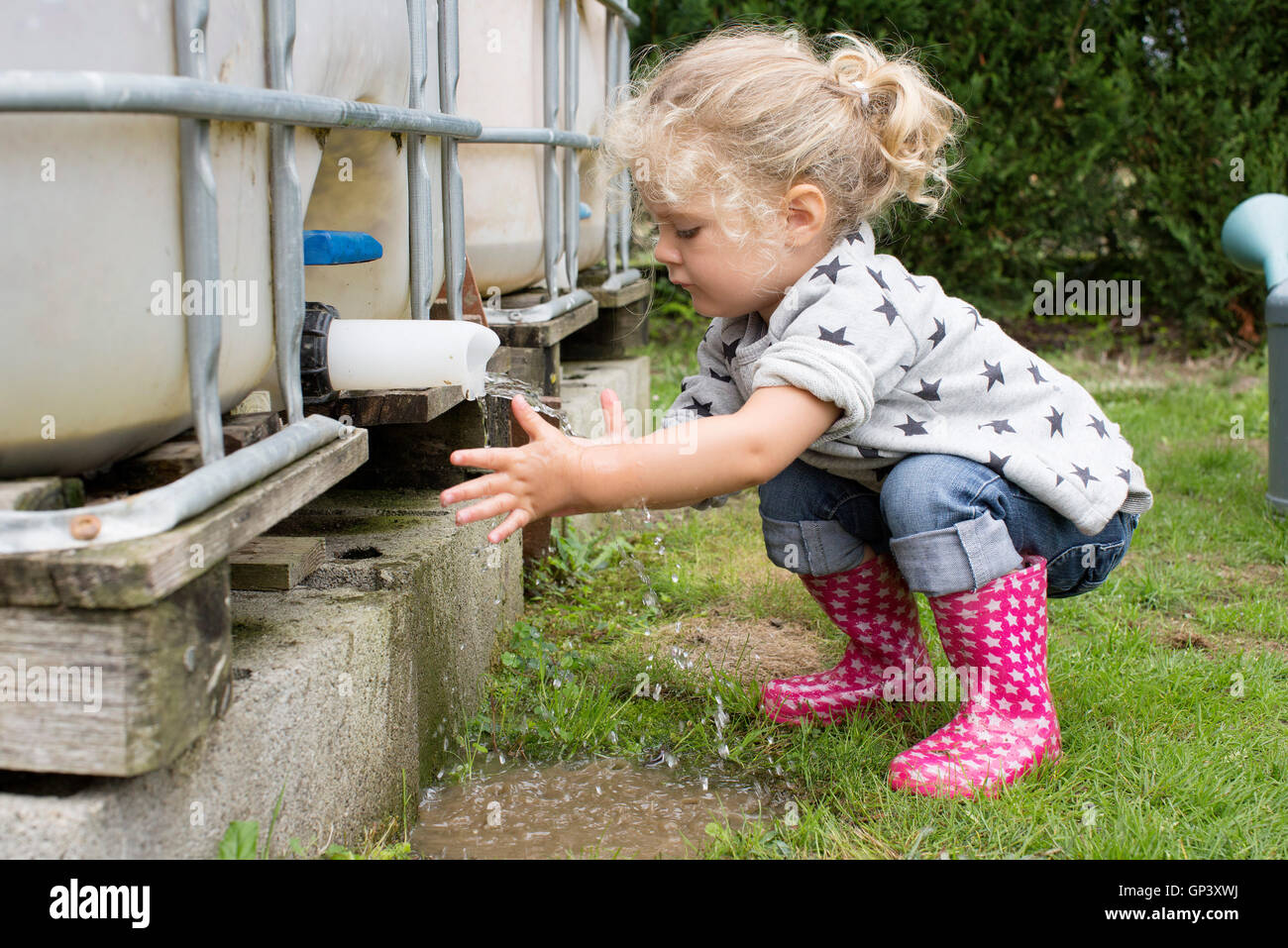 Little girl washing hands under outdoor cistern spigot Stock Photo - Alamy