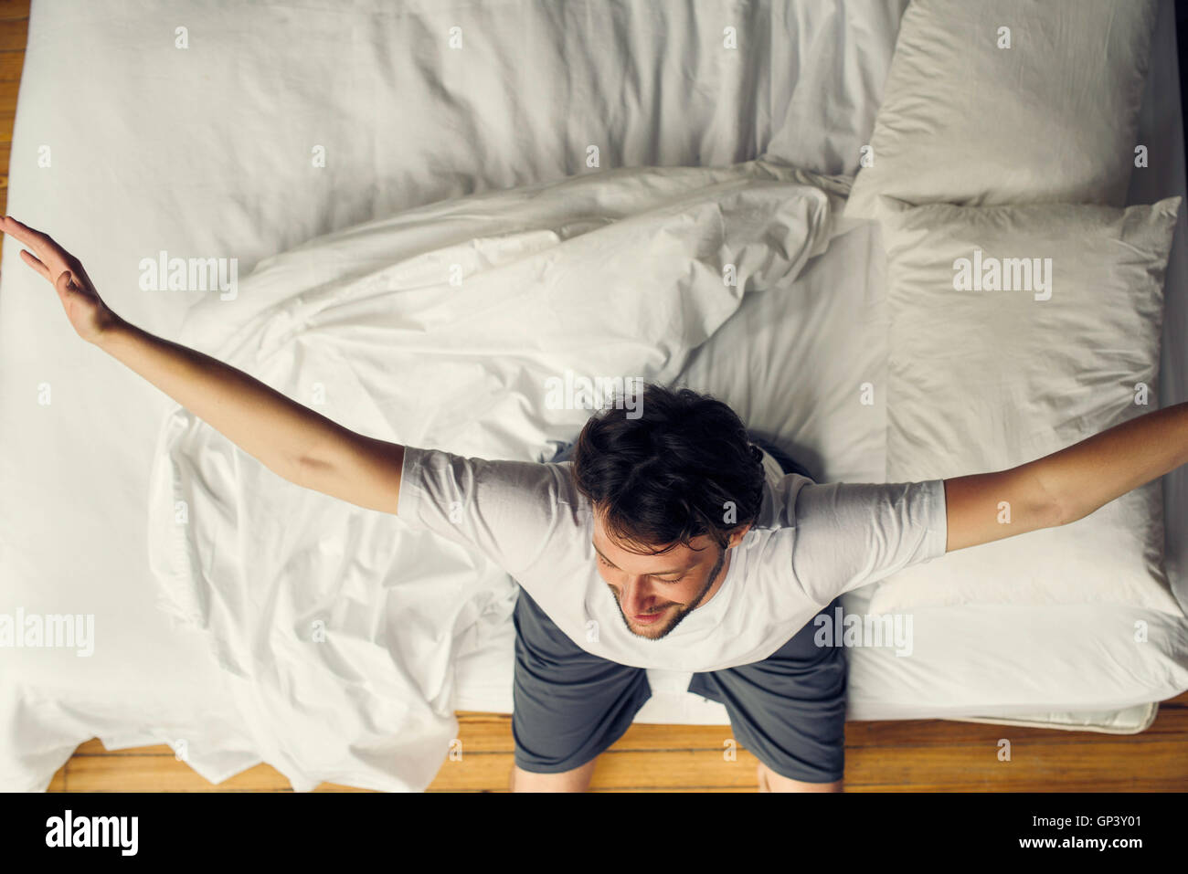 Man stretching in bed Stock Photo - Alamy