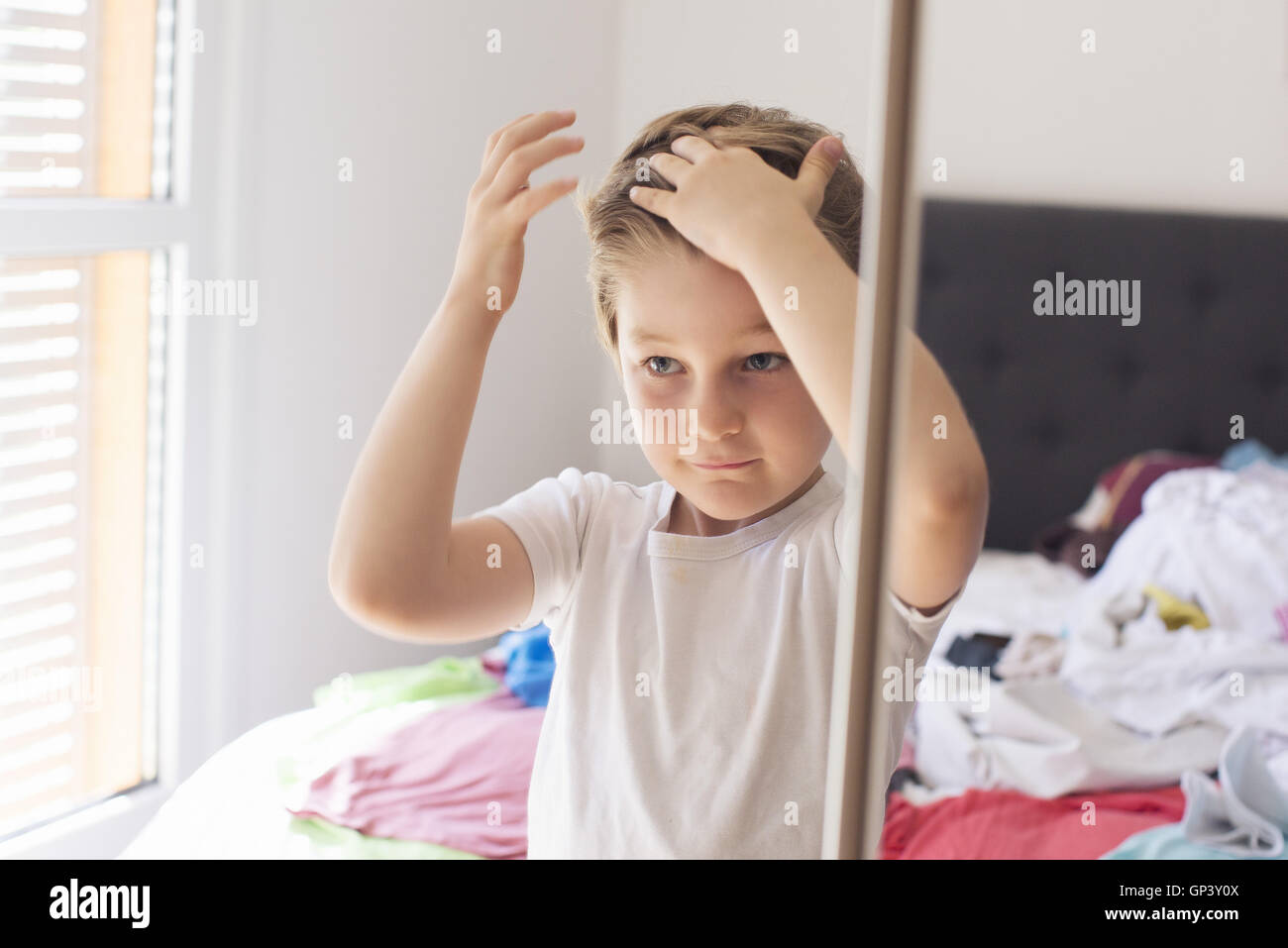 Boy fixing hair in front of mirror Stock Photo - Alamy