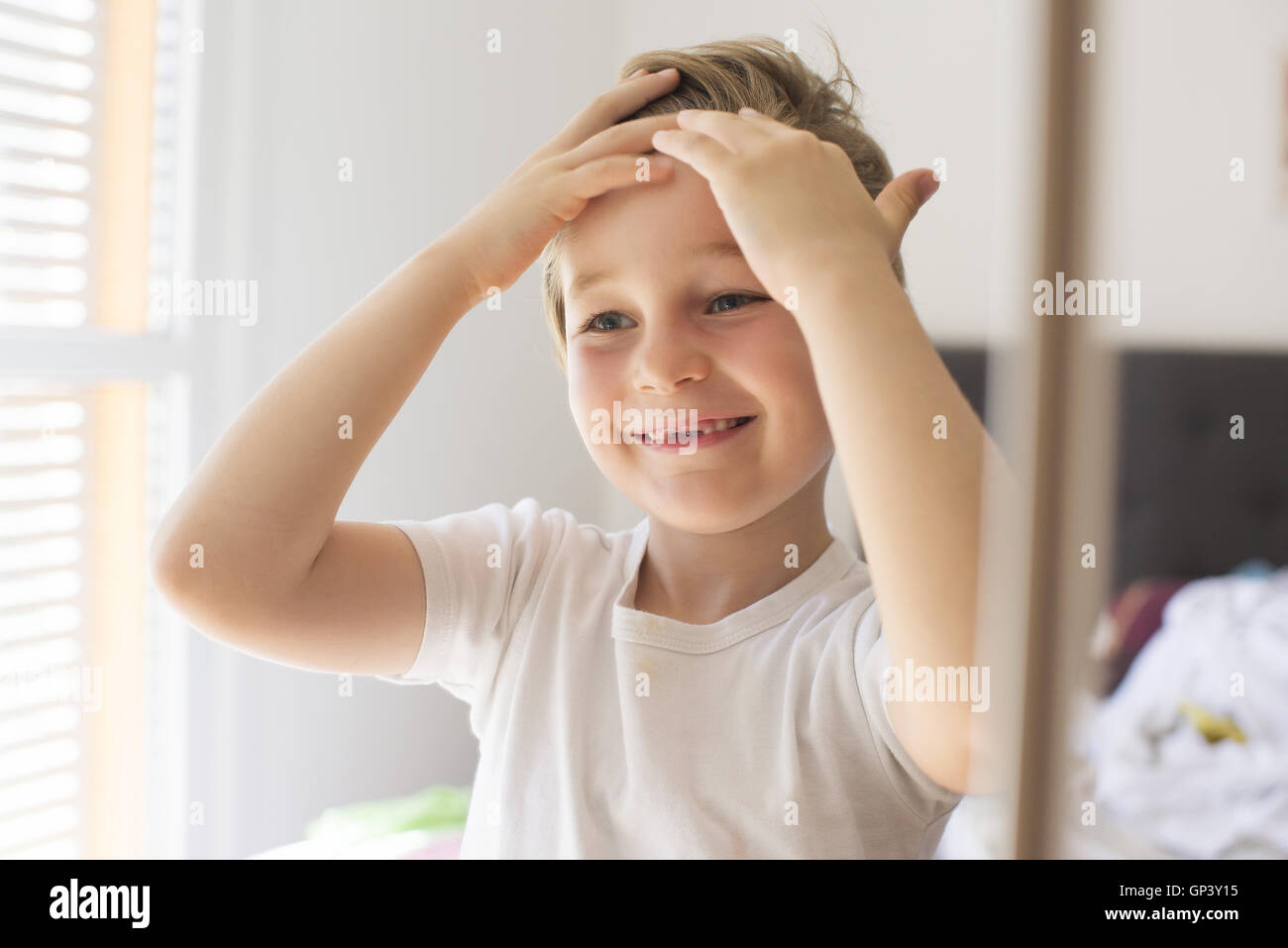 Boy fixing hair in front of mirror Stock Photo - Alamy
