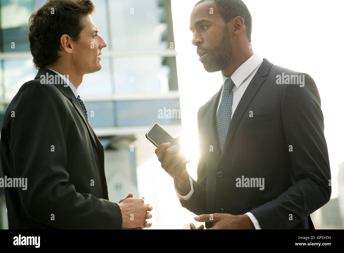 Businessmen talking outdoors Stock Photo - Alamy