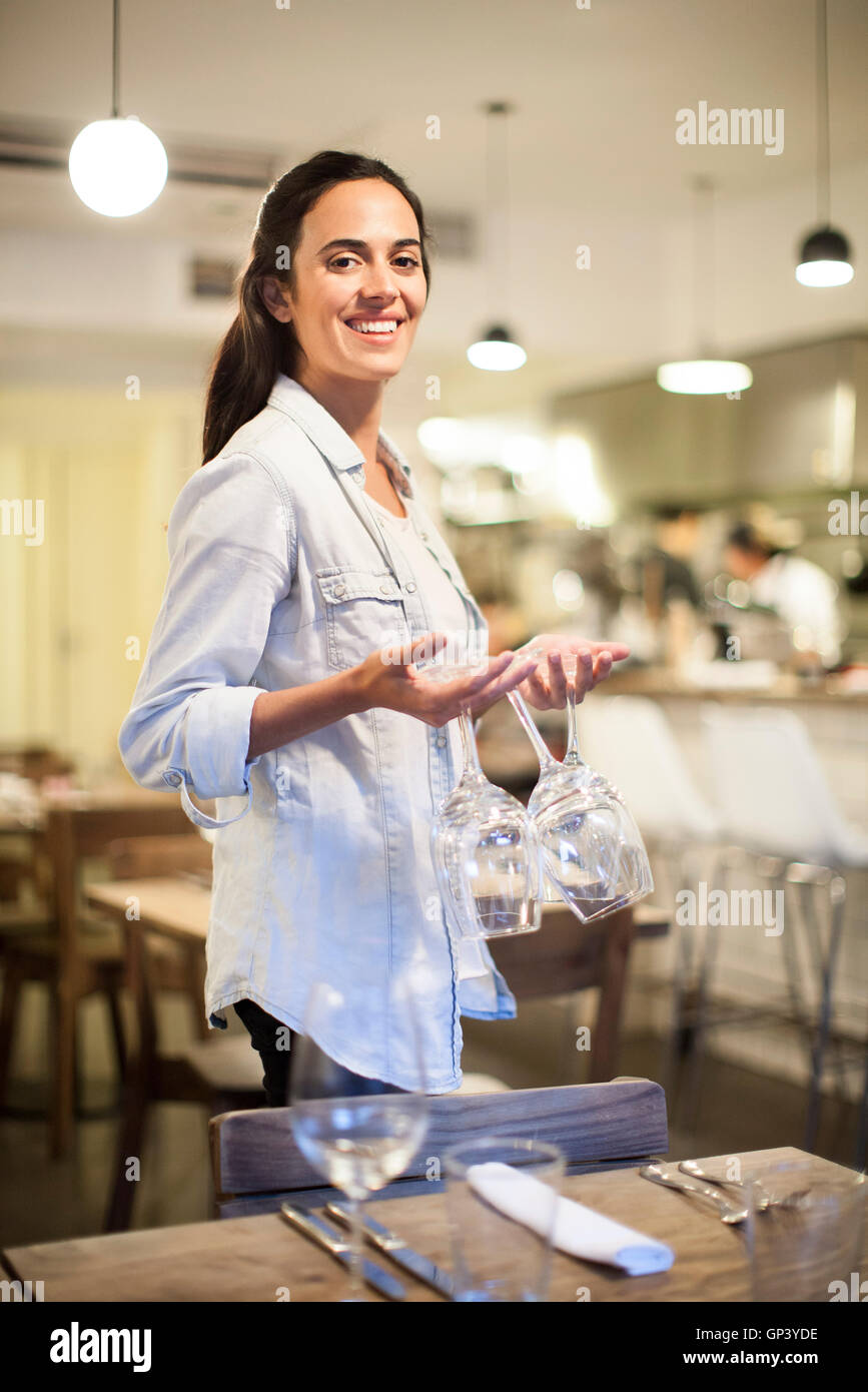 Waitress setting table at restaurant, portrait Stock Photo - Alamy
