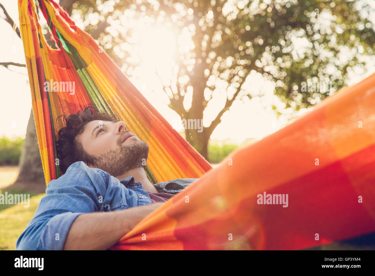 Man relaxing in hammock Stock Photo - Alamy