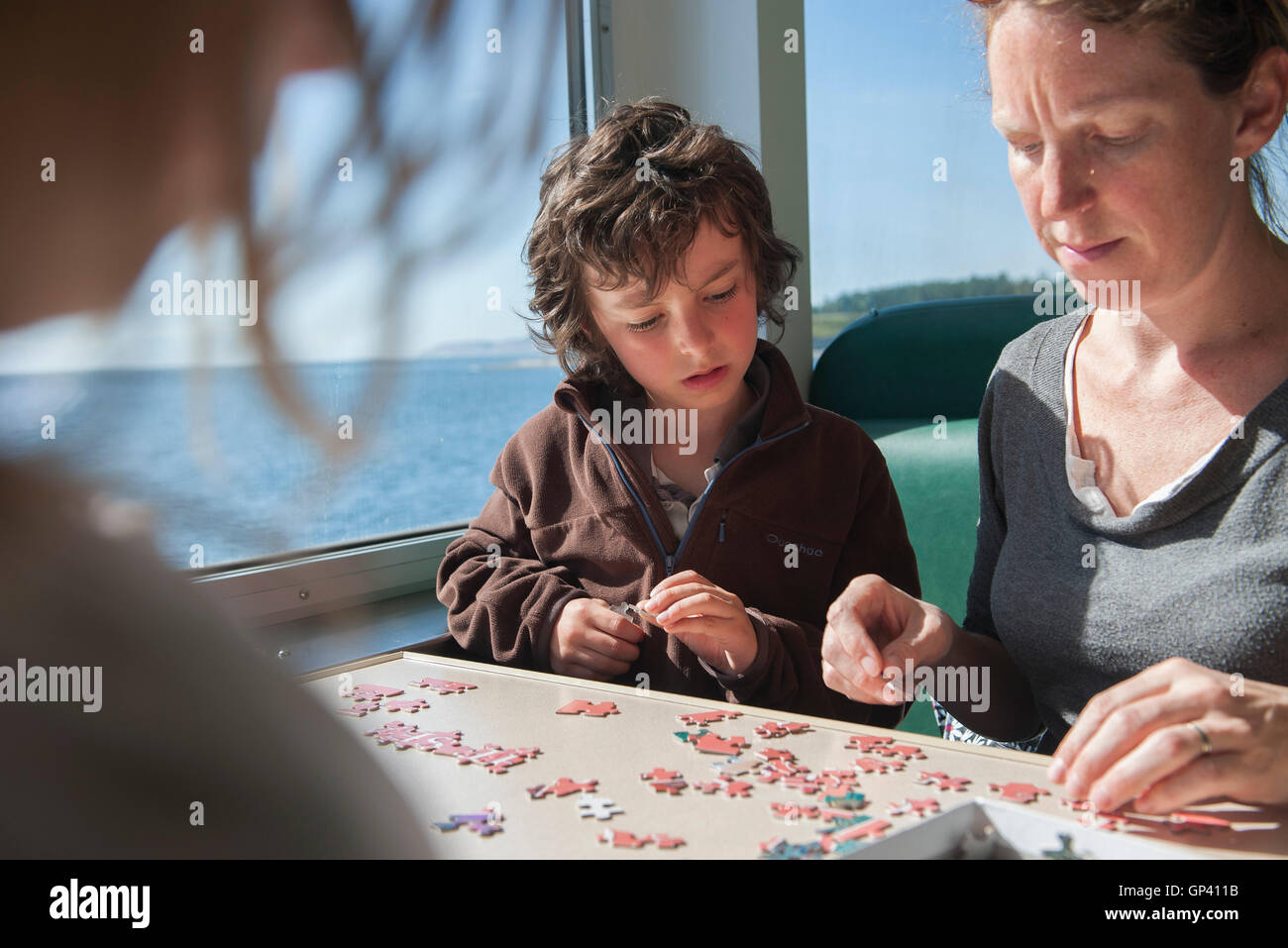 Family putting together jigsaw puzzle together Stock Photo - Alamy
