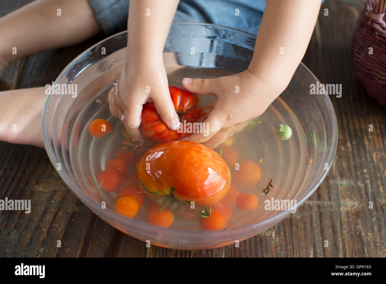Child washing tomatoes Stock Photo - Alamy