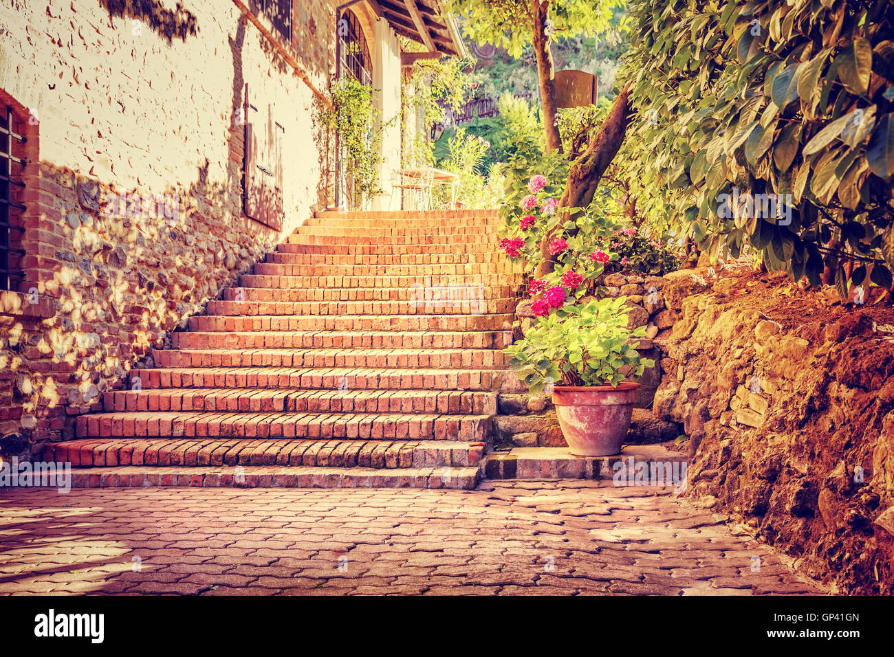 Beautiful old street, vintage stairs near house decorated with flowers ...