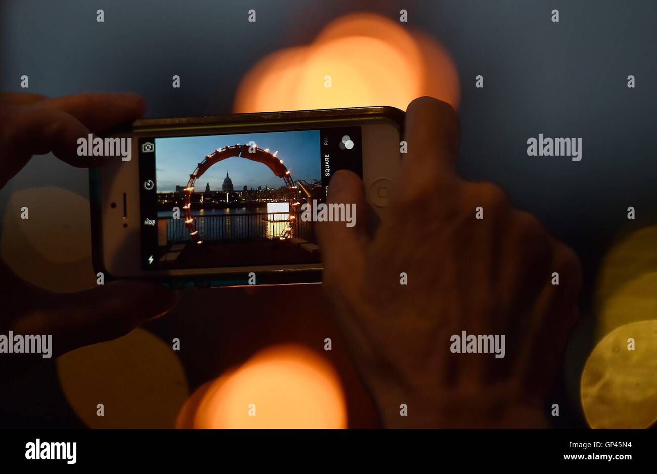 A woman photographs a burning structure as part of 'Fire Garden' by ...