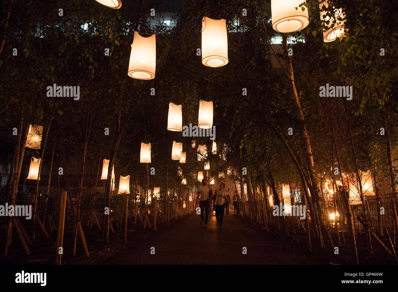 People walk through a pathway of burning tshirts as part of 'Fire ...