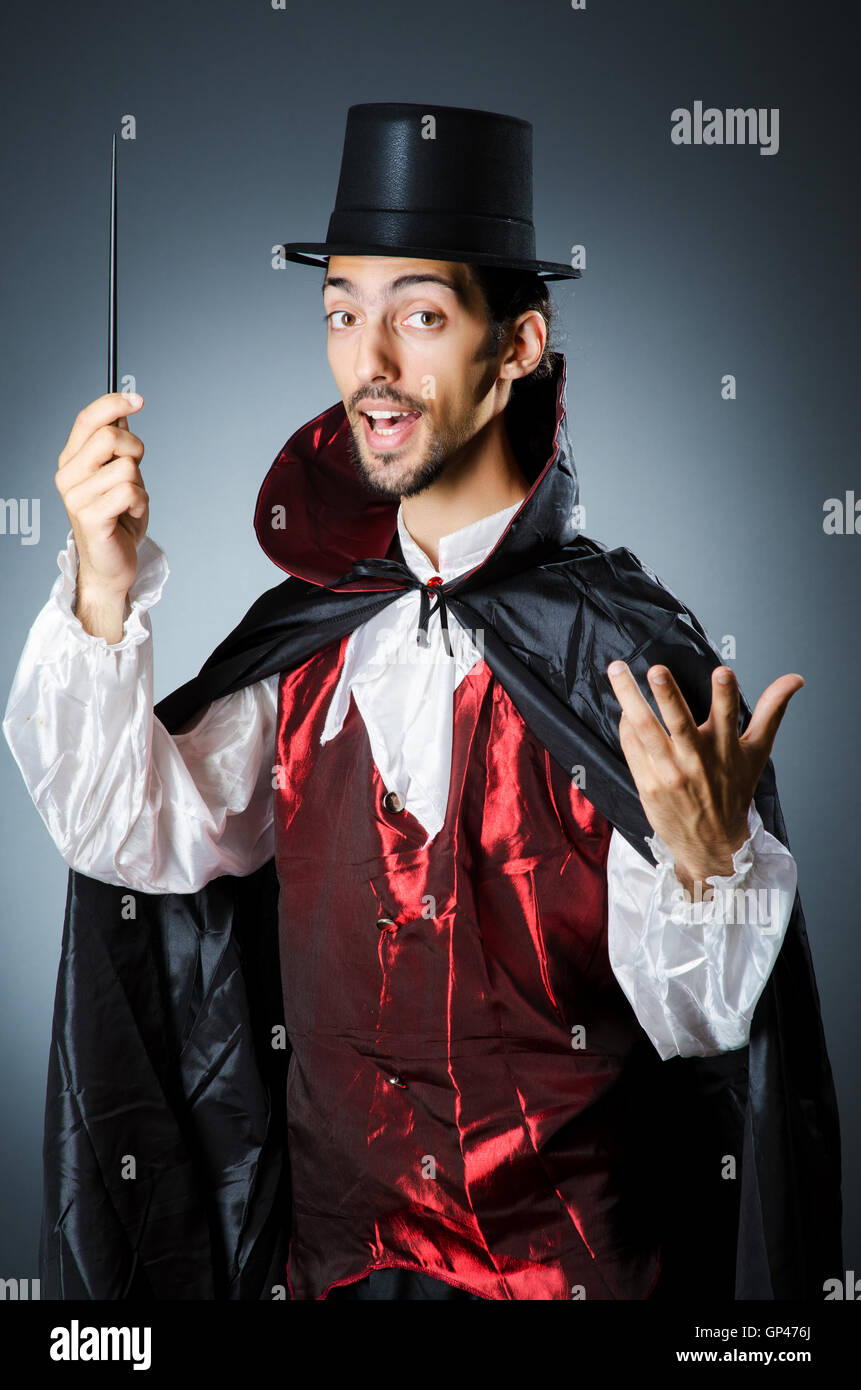 Magician doing tricks in dark room Stock Photo - Alamy