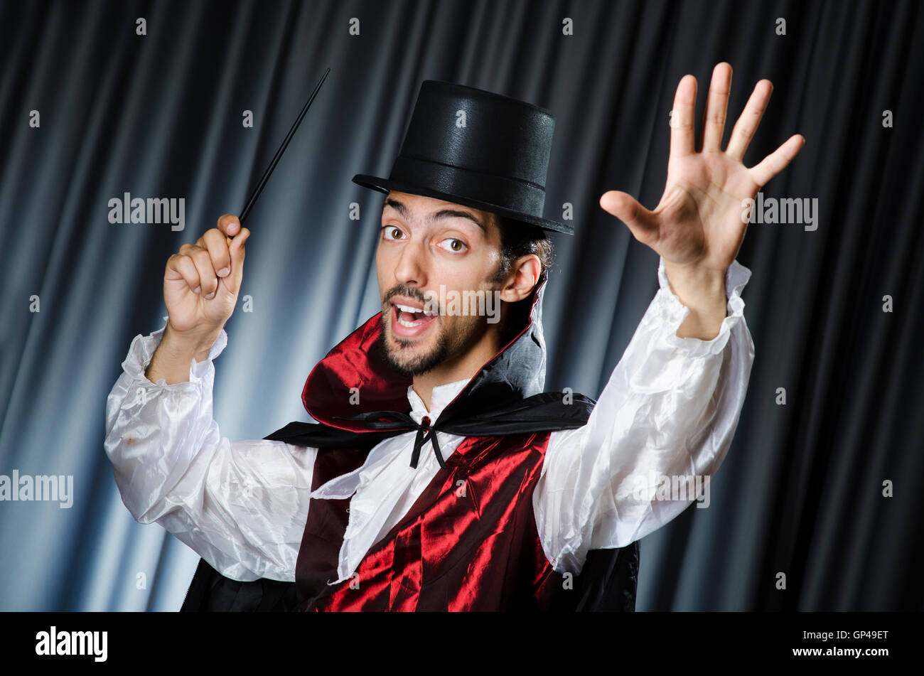 Magician doing tricks in dark room Stock Photo - Alamy