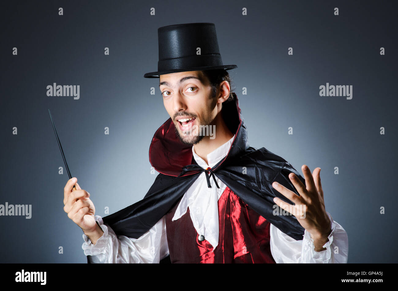 Magician doing tricks in dark room Stock Photo - Alamy