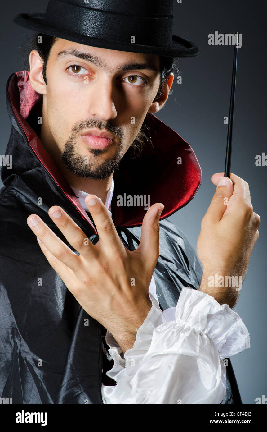 Magician doing tricks in dark room Stock Photo - Alamy