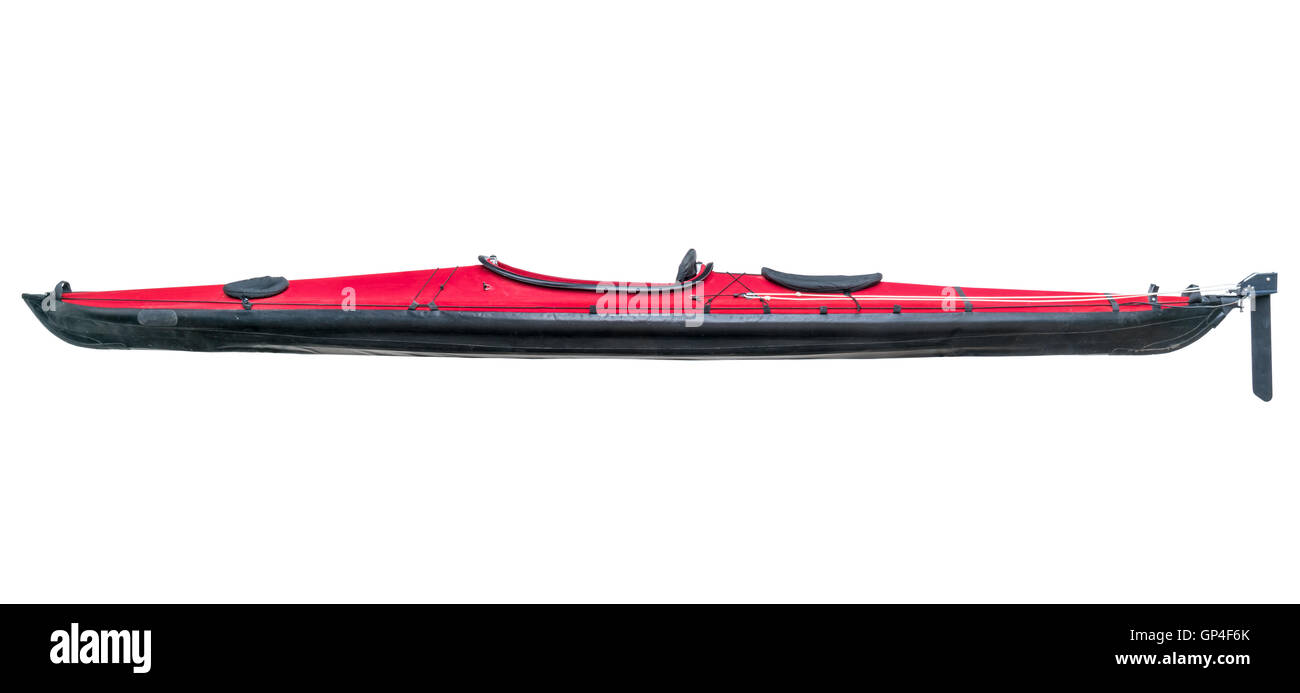 a side view of a folding sea kayak with a red deck and rudder isolated ...