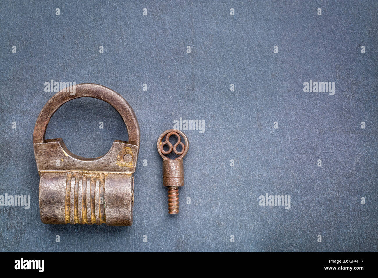 Vintage round shape hand crafted screw type iron padlock with a key on ...