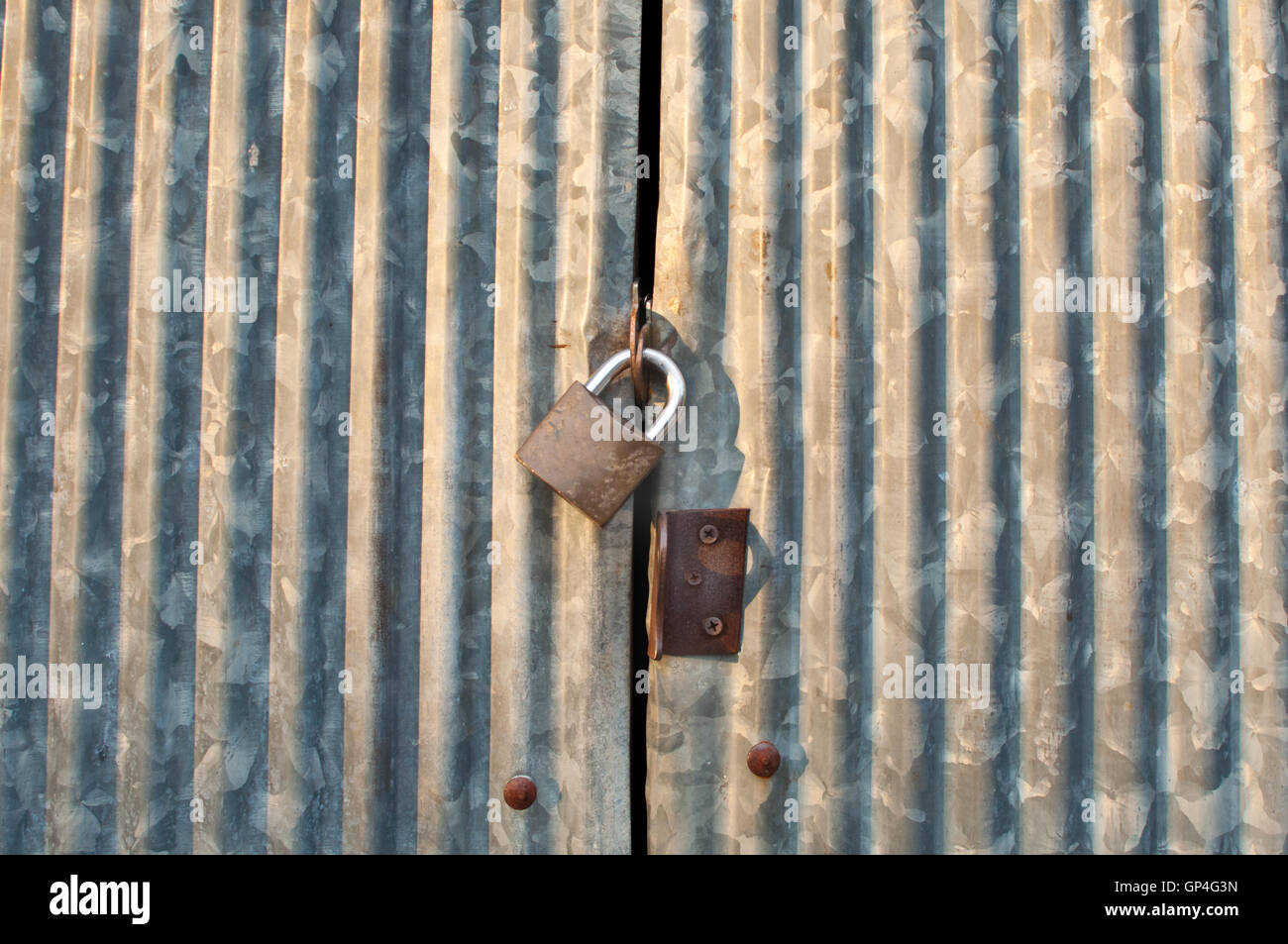 Closed wave metal door with metal lock Stock Photo - Alamy