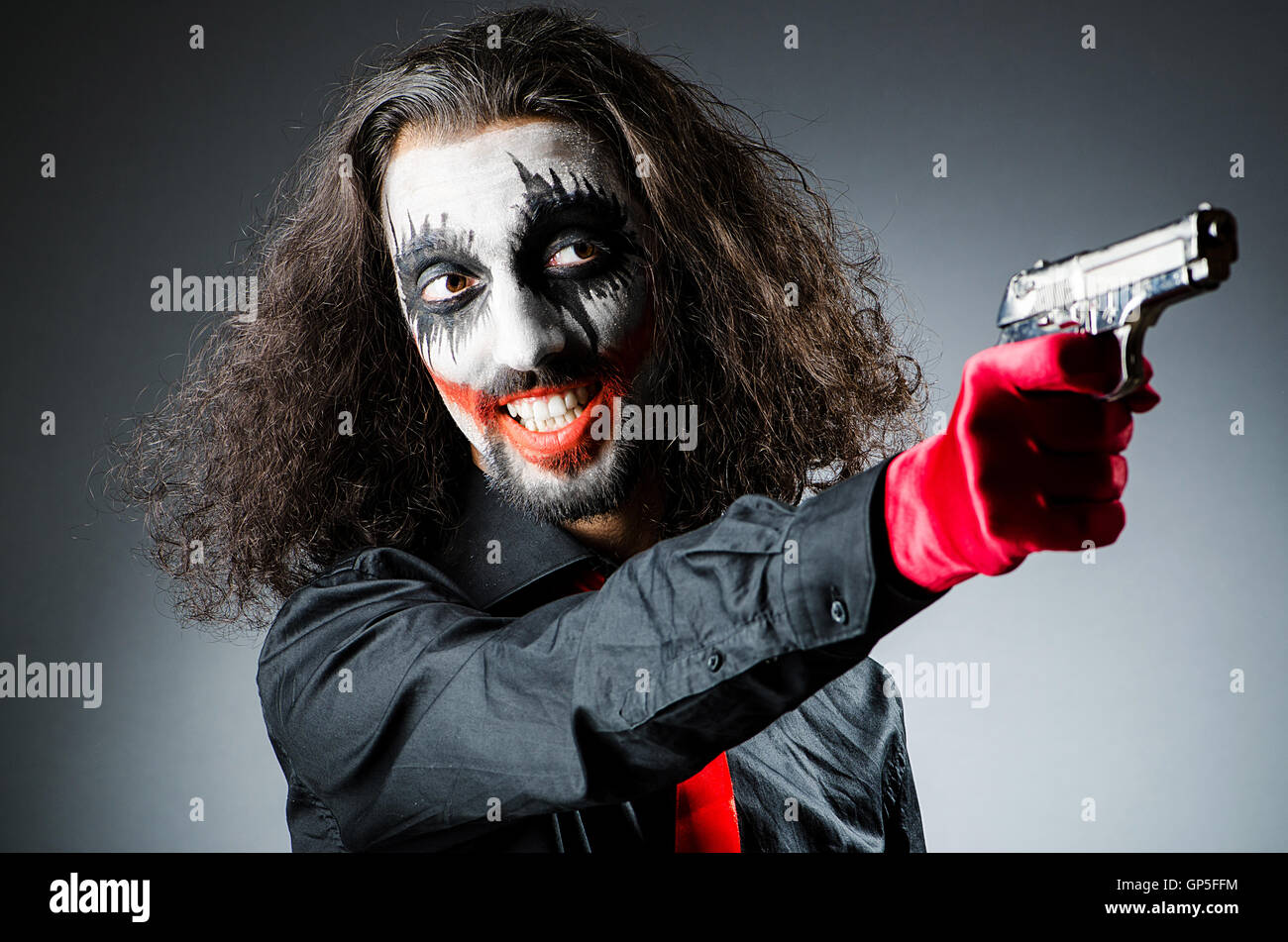 Evil clown with gun in dark room Stock Photo - Alamy