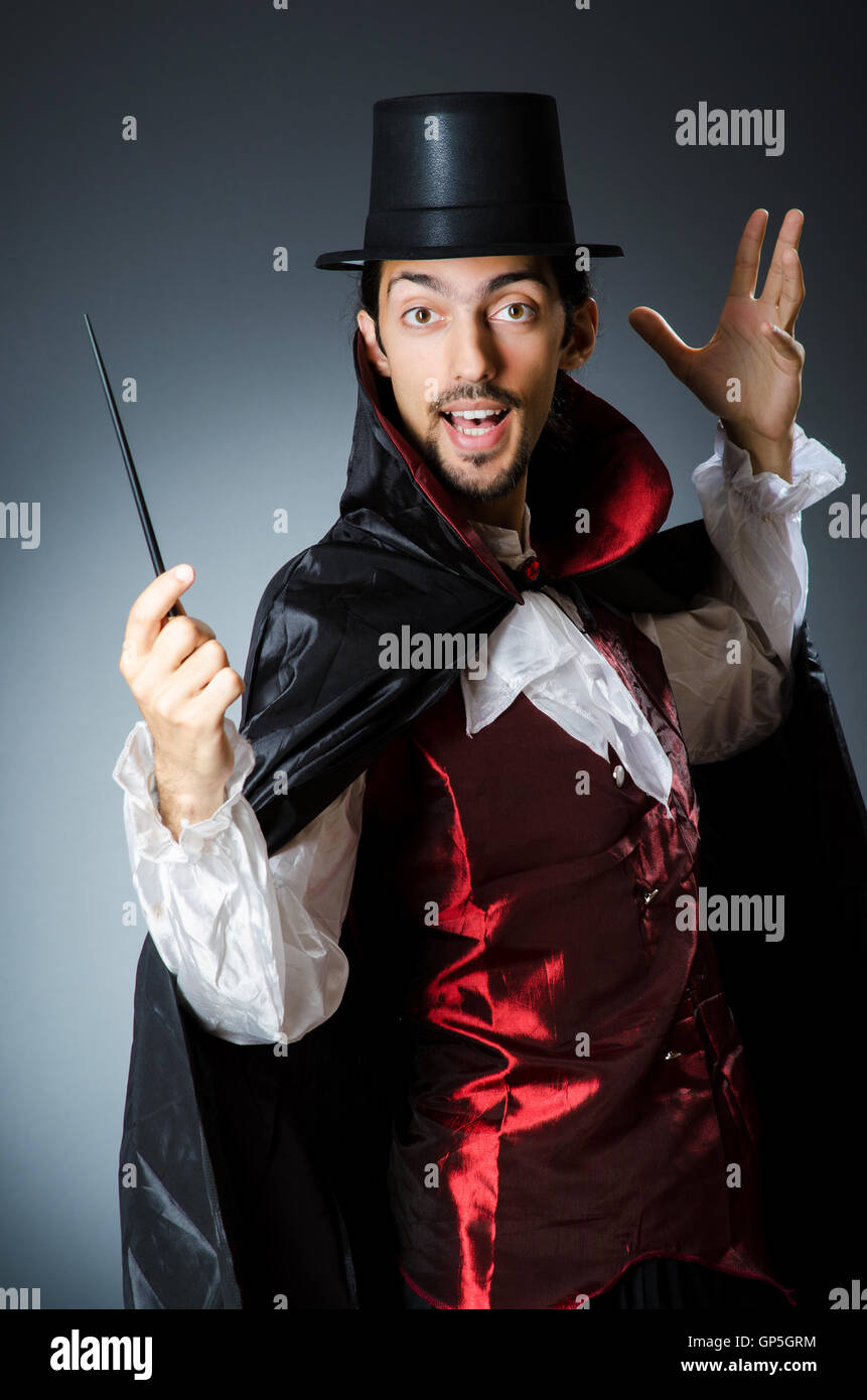 Magician doing tricks in dark room Stock Photo - Alamy