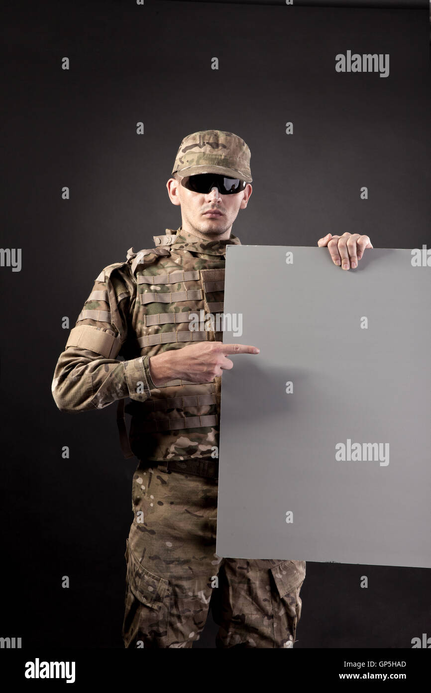 Modern soldier is holding a poster Stock Photo - Alamy