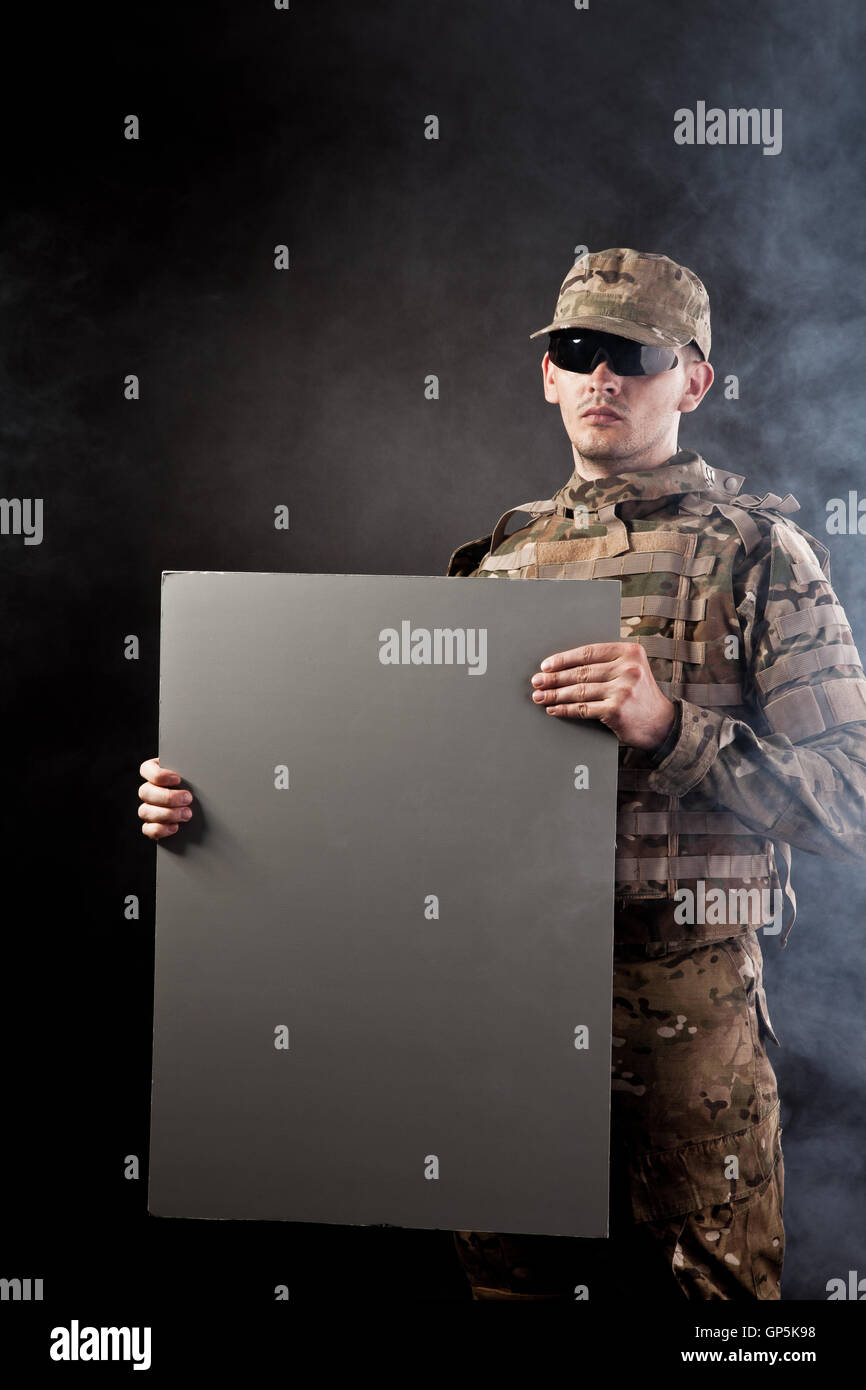 Modern soldier is holding a poster Stock Photo - Alamy