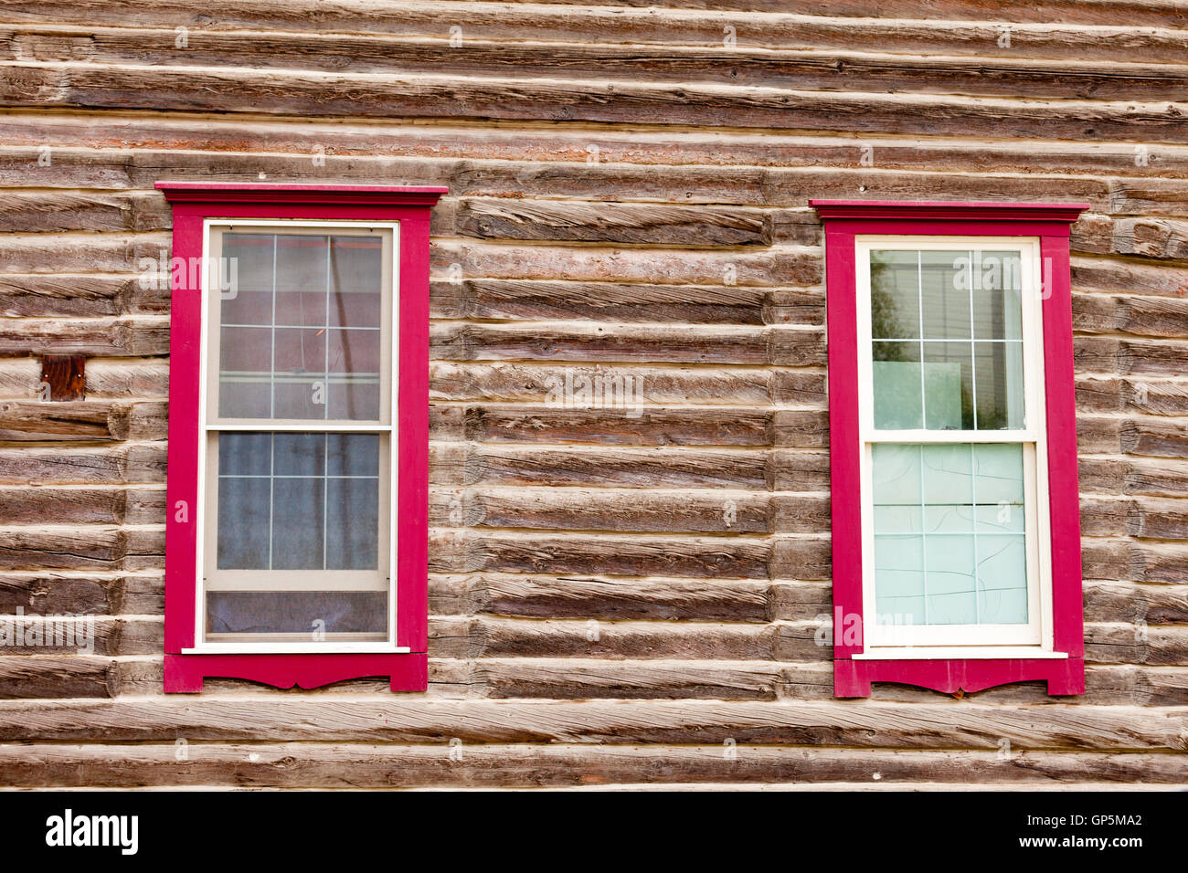 Red framed windows in log house wall architecture Stock Photo - Alamy
