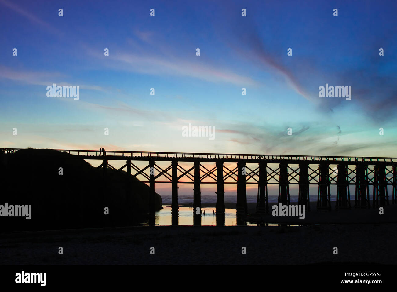 Couple on foot bridge watching the sunset over Fort Bragg while ...