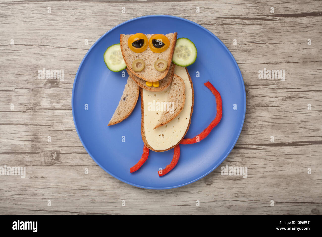 Monkey made of bread, cheese and vegetables on wooden background and ...