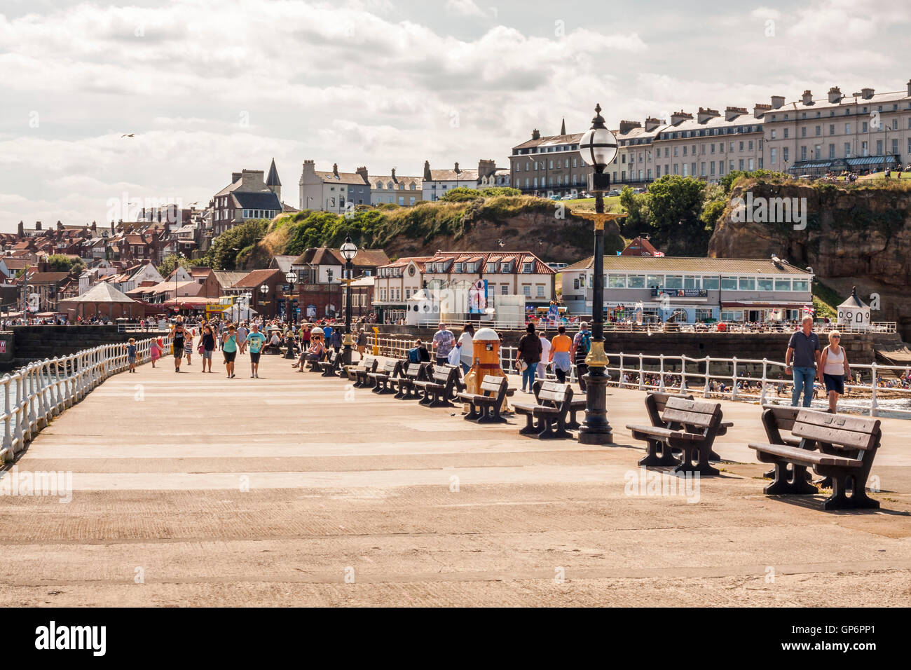 A view of the pier and west cliff at Whitby,North Yorkshire on a busy ...