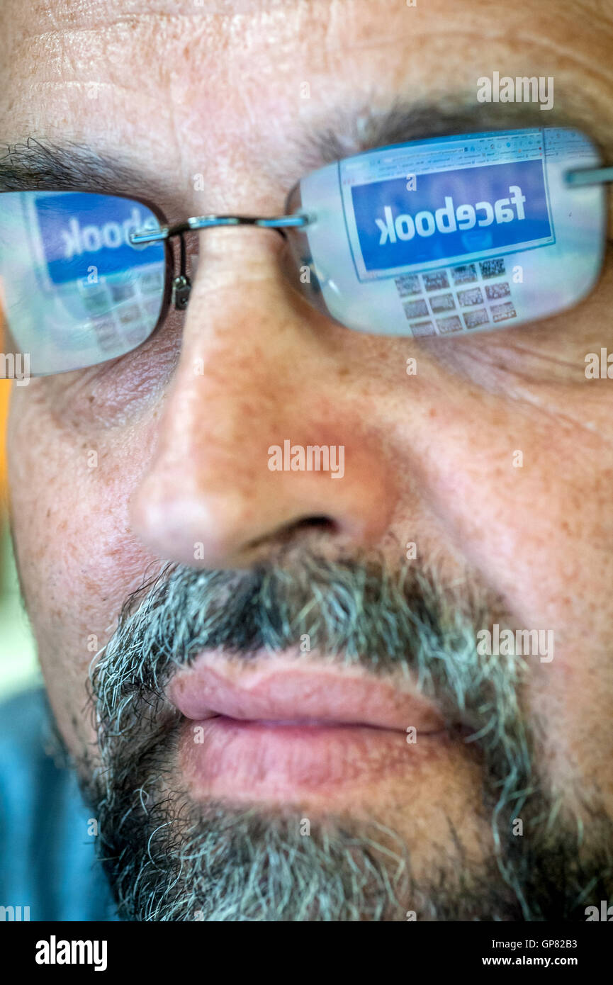 The Facebook logo reflected in a man's eyes and glasses Stock Photo - Alamy