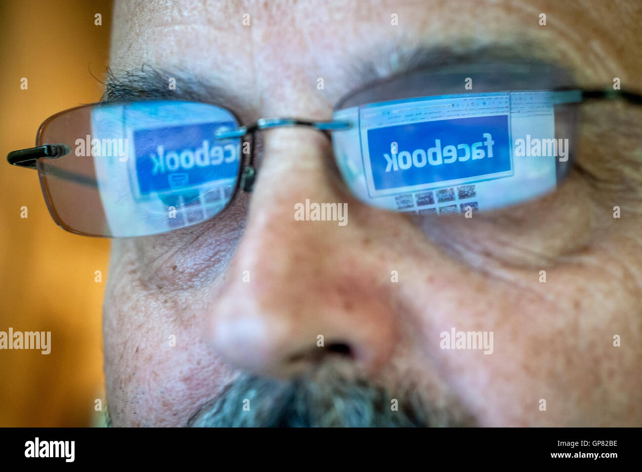 The Facebook logo reflected in a man's eyes and glasses Stock Photo - Alamy