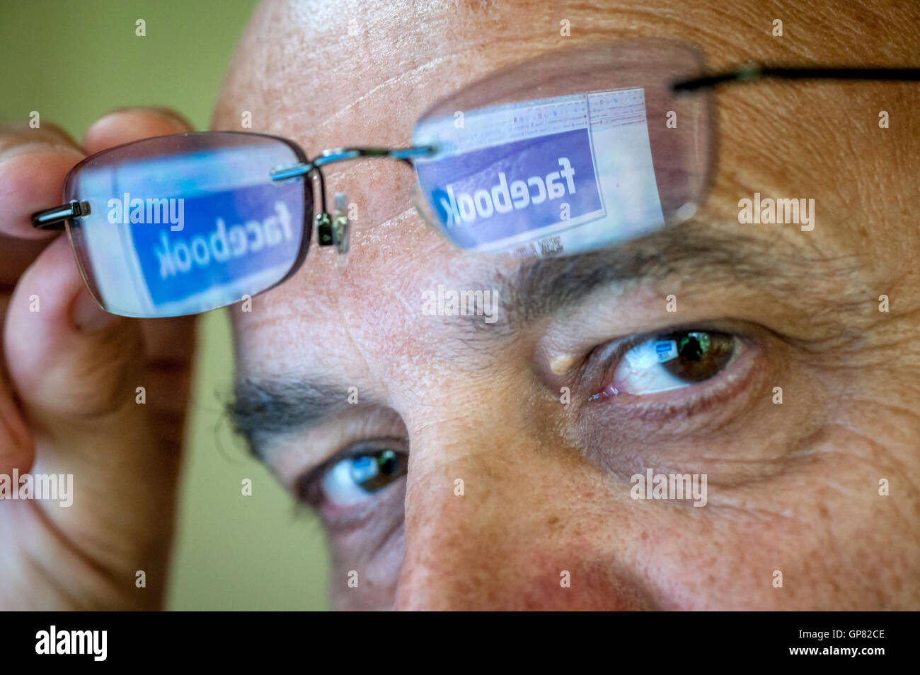 The Facebook logo reflected in a man's eyes and glasses Stock Photo - Alamy