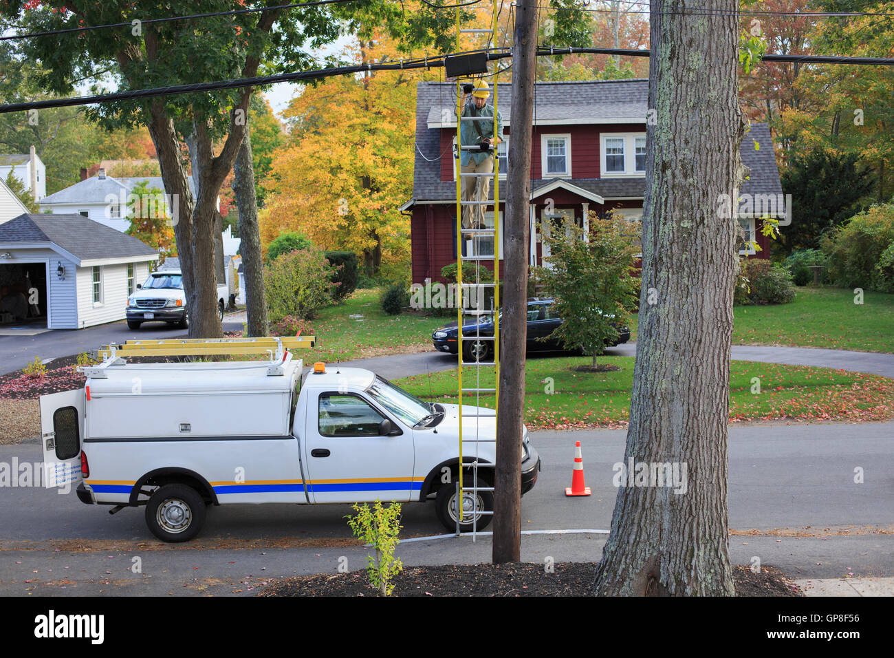 Lineman on ladder working on cable lines on power pole Stock Photo - Alamy