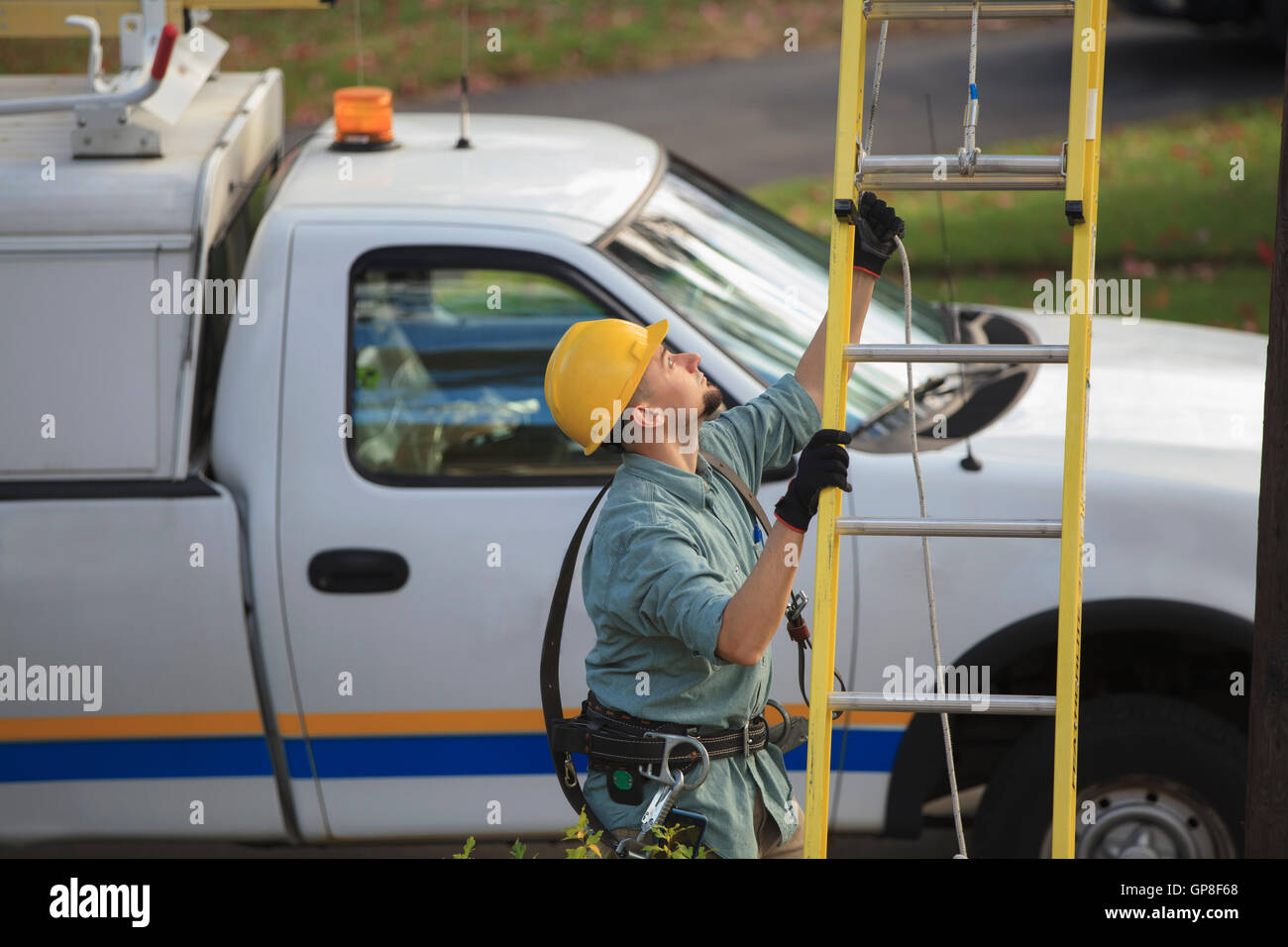 Lineman placing ladder at power pole Stock Photo - Alamy