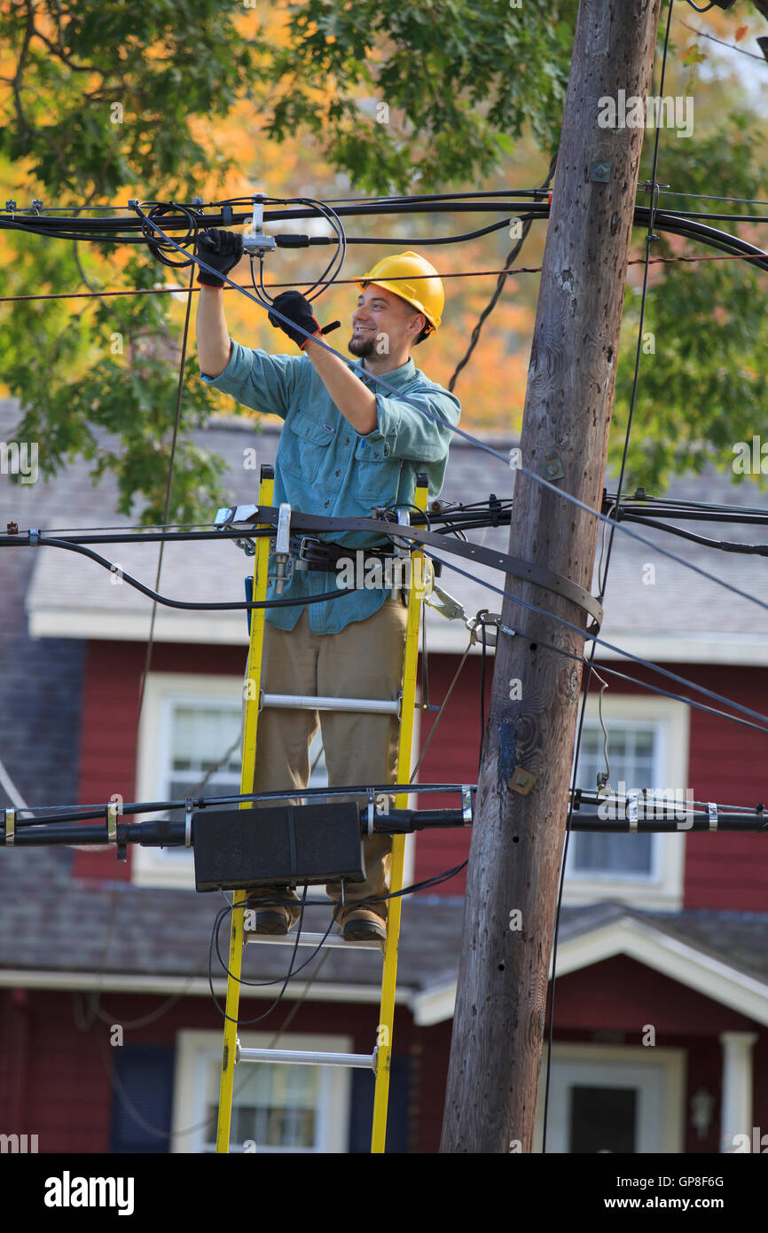 Lineman working on cables at power pole Stock Photo - Alamy