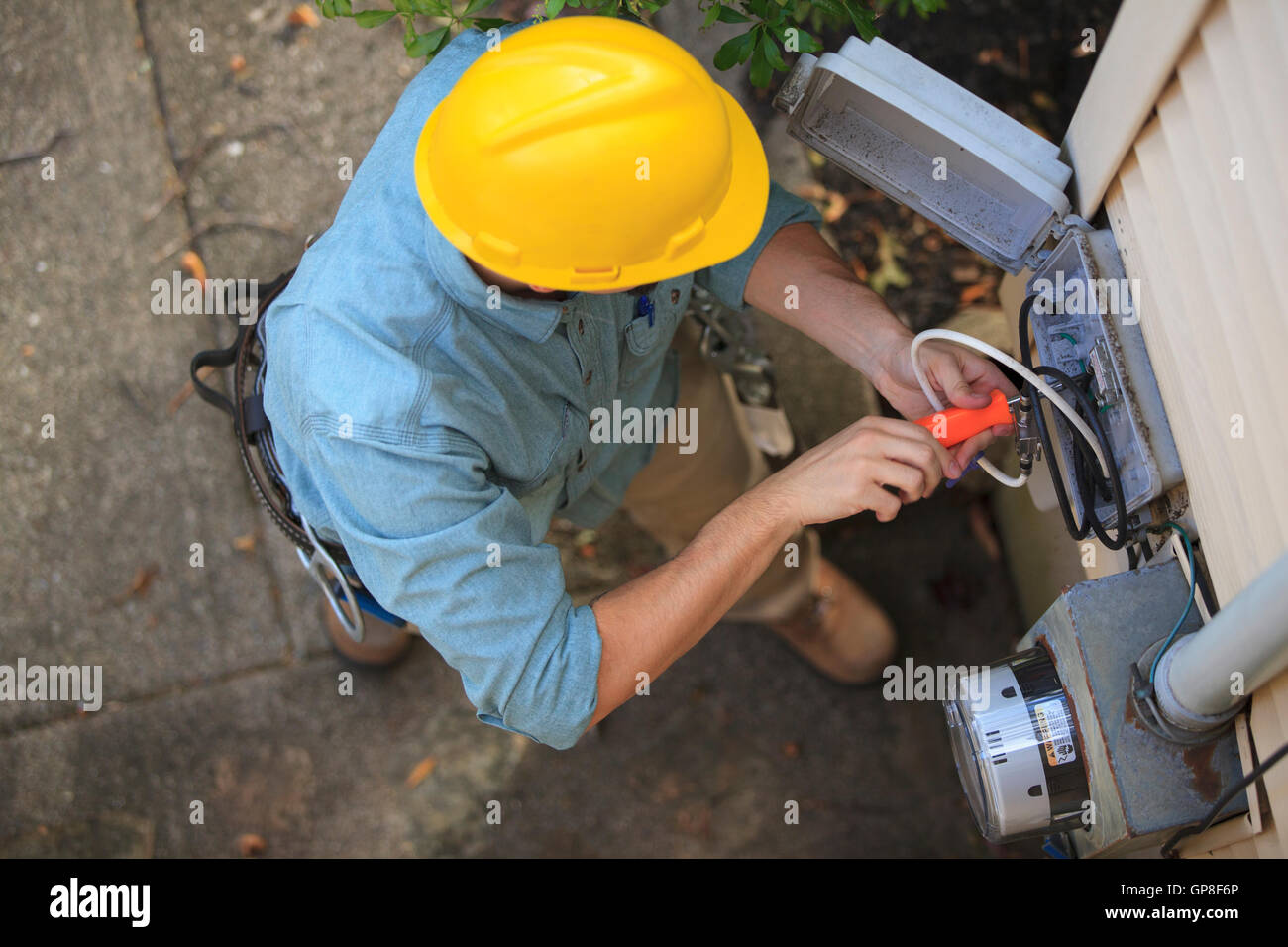 Lineman working on cable at connection box at a home Stock Photo - Alamy