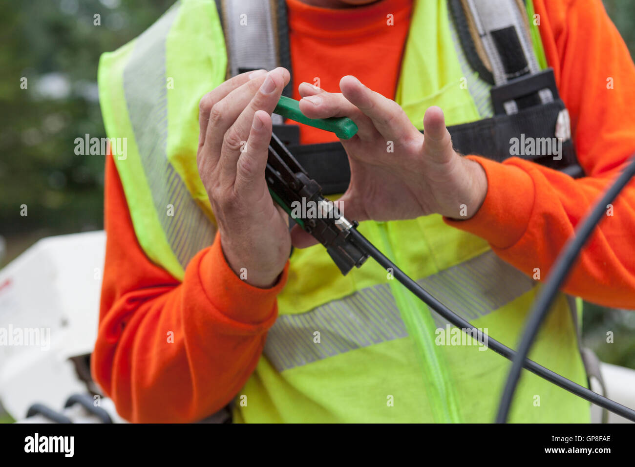 Cable lineman crimping connector to a cable from a bucket truck Stock ...