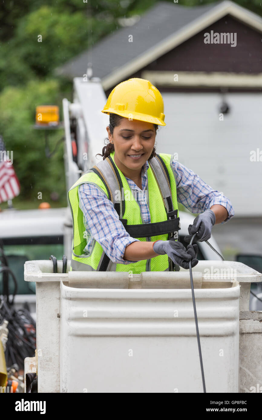 Hispanic female cable lineman stringing a new line Stock Photo - Alamy